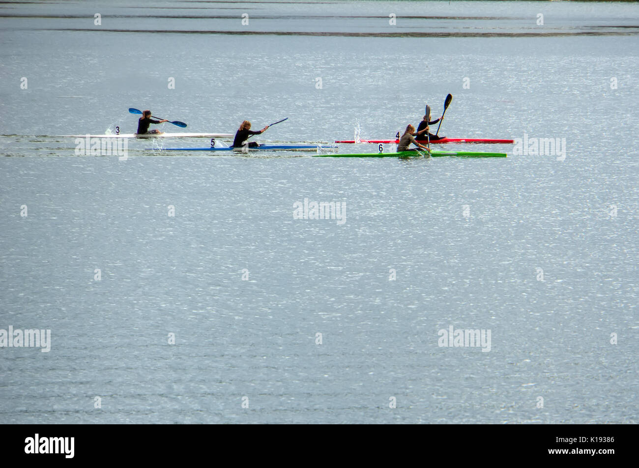 girls rowing on kayaks on the lake. Rowing competitions in open water ...