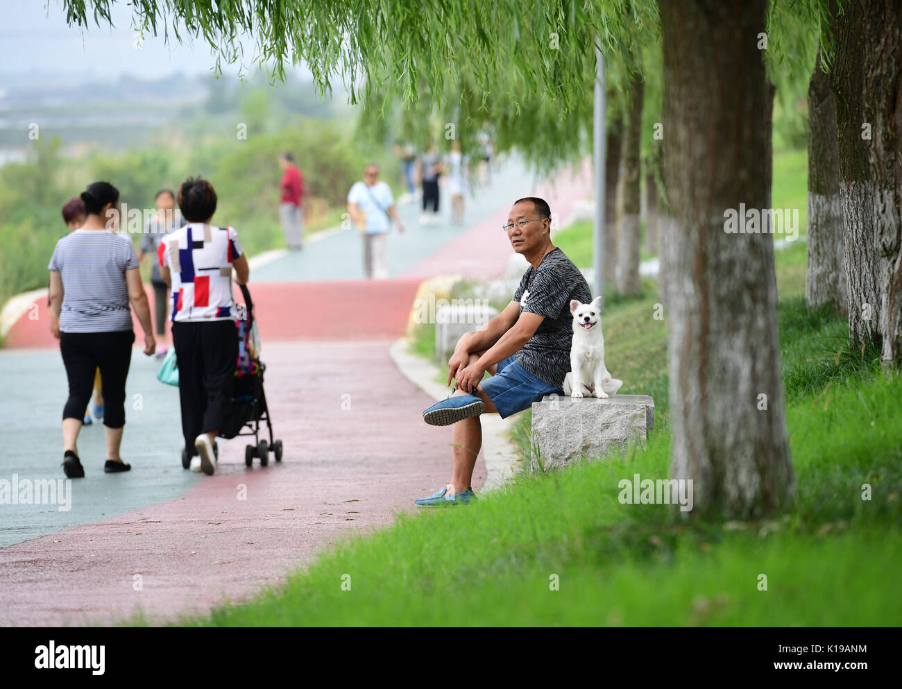 Ankang, China's Shaanxi Province. 26th Aug, 2017. People walk and rest ...