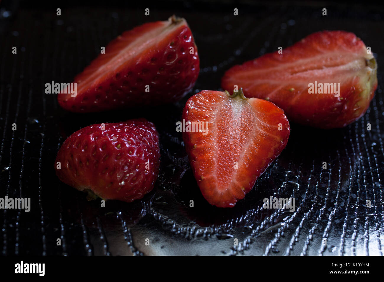 cutting strawberry on black tray Stock Photo - Alamy