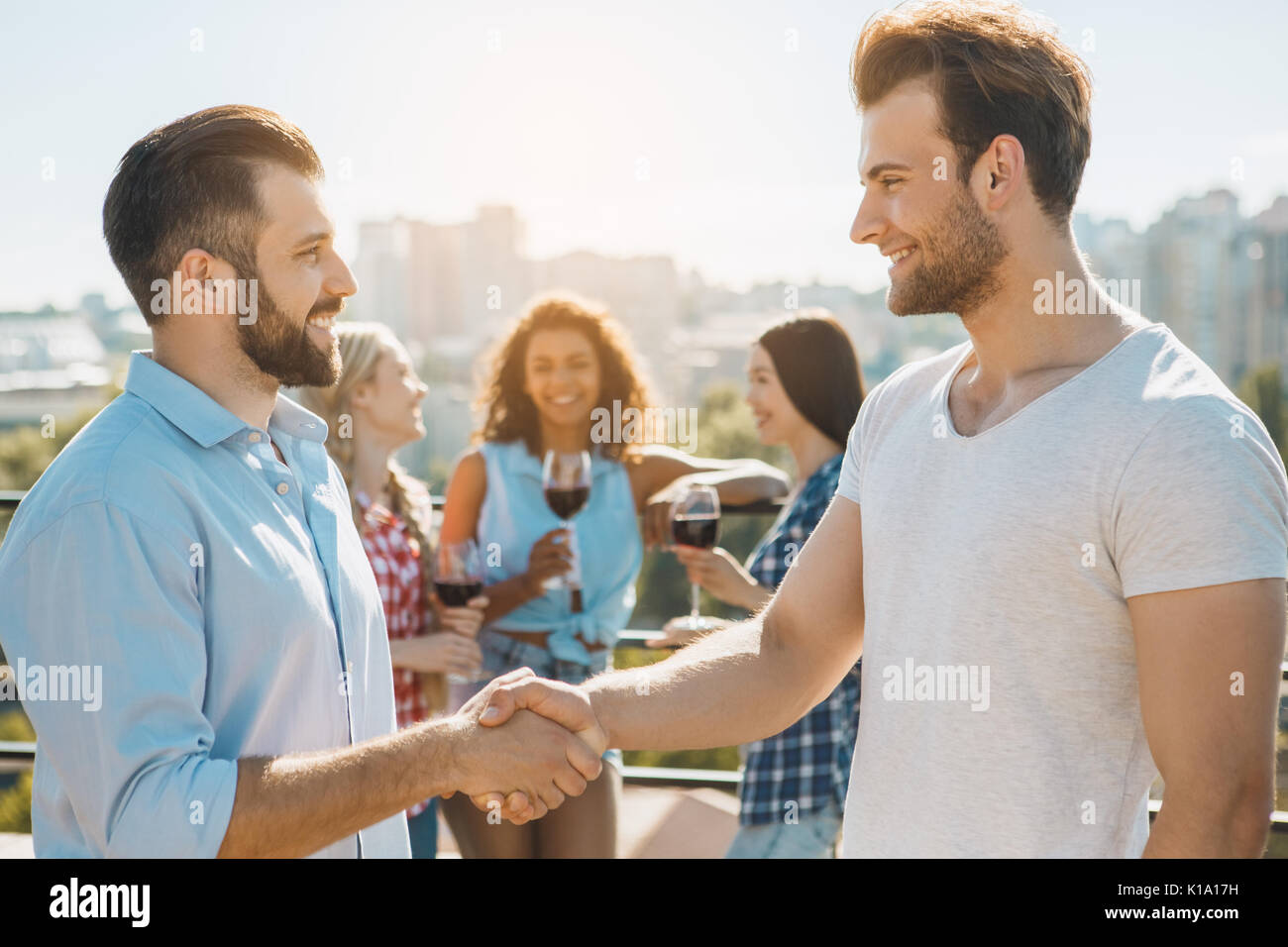 Group of people having barbecue party handshake Stock Photo - Alamy