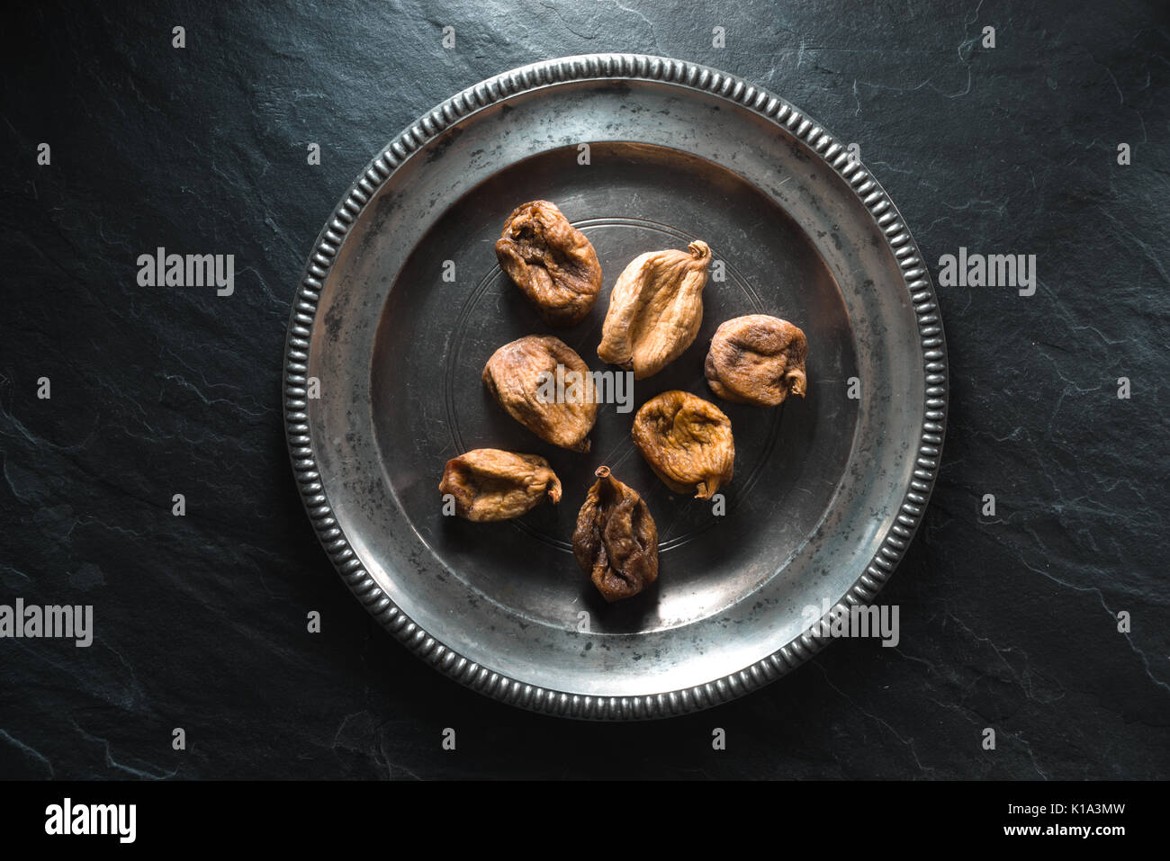 Dry figs on a tin plate on a gray stone horizontal Stock Photo - Alamy