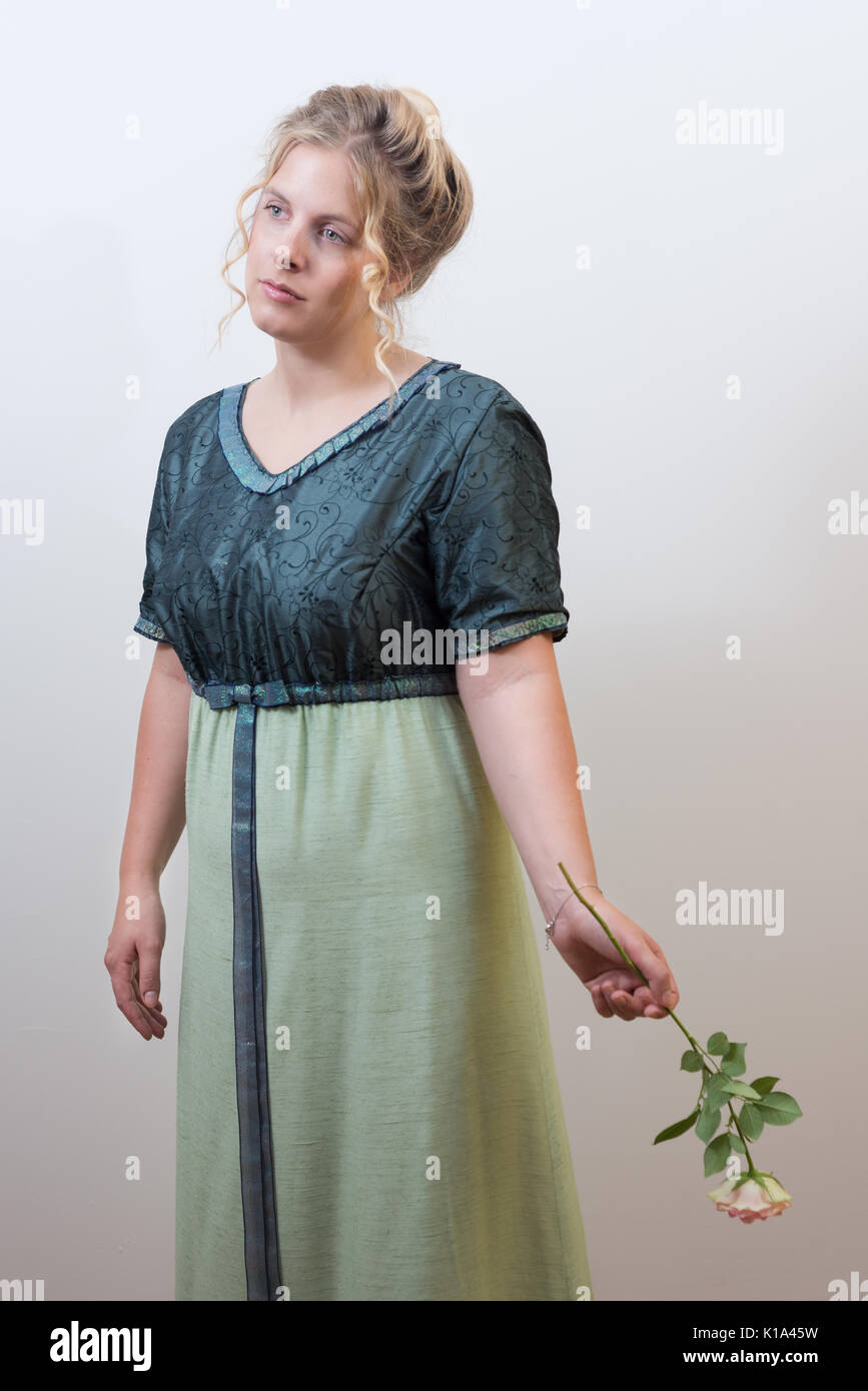 Beautiful blonde regency young woman holding a rose Stock Photo - Alamy