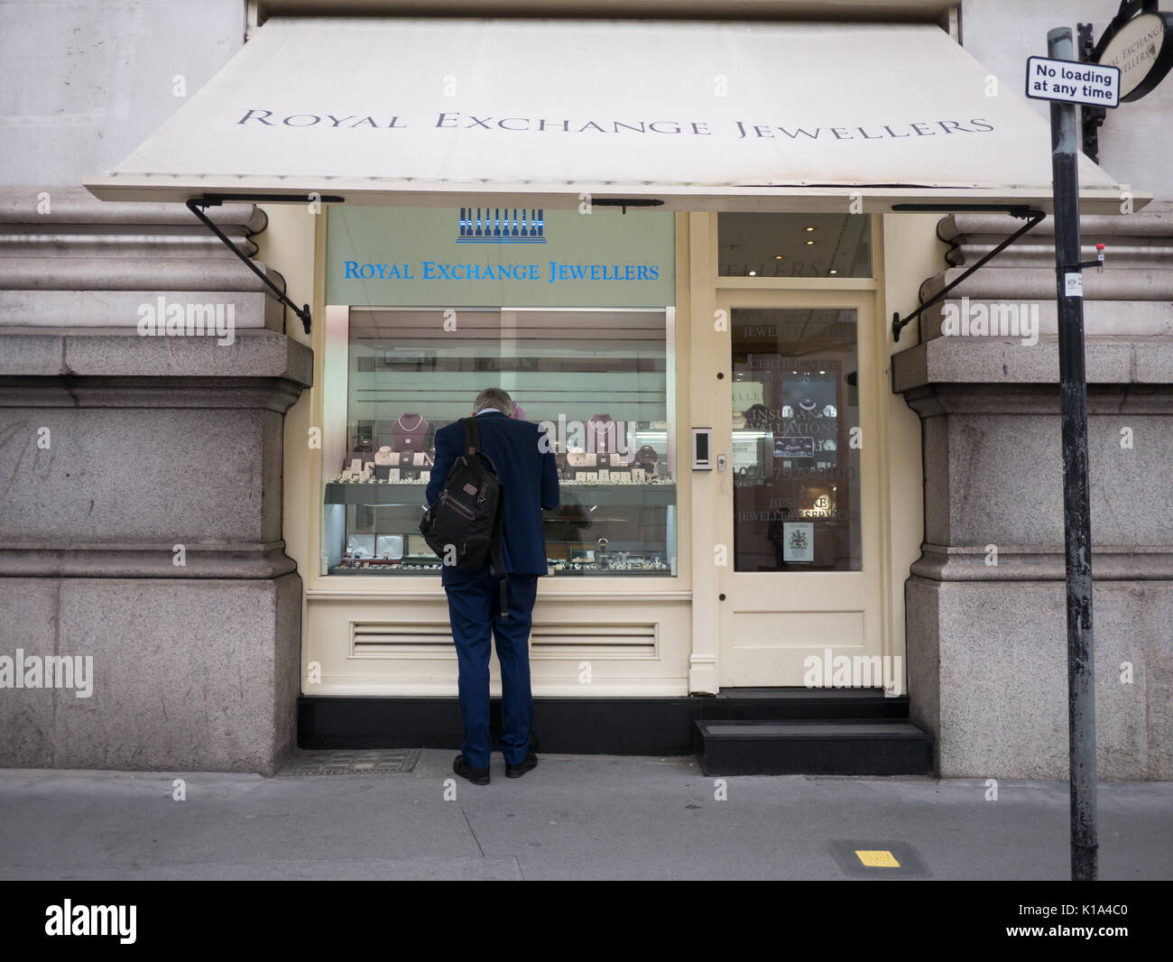 man in suit looking in window of Luxury shopping at Royal Exchange ...