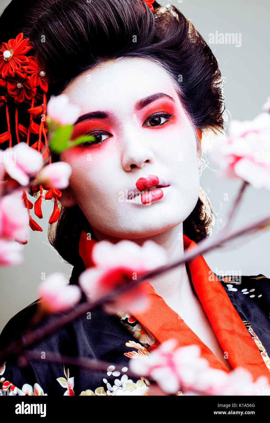 young pretty geisha in kimono with sakura and red decoration design on ...