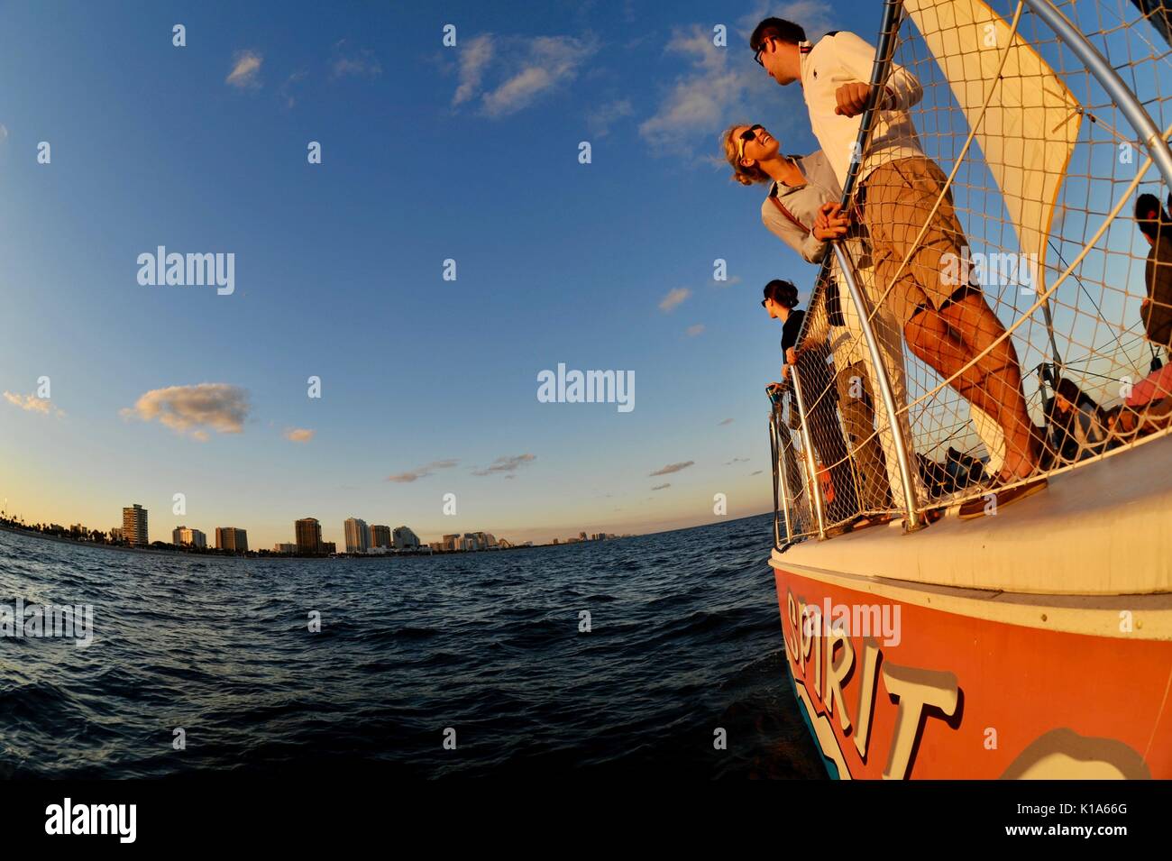 Attractive young couple on catamaran sailboat during sunset cruise on ...
