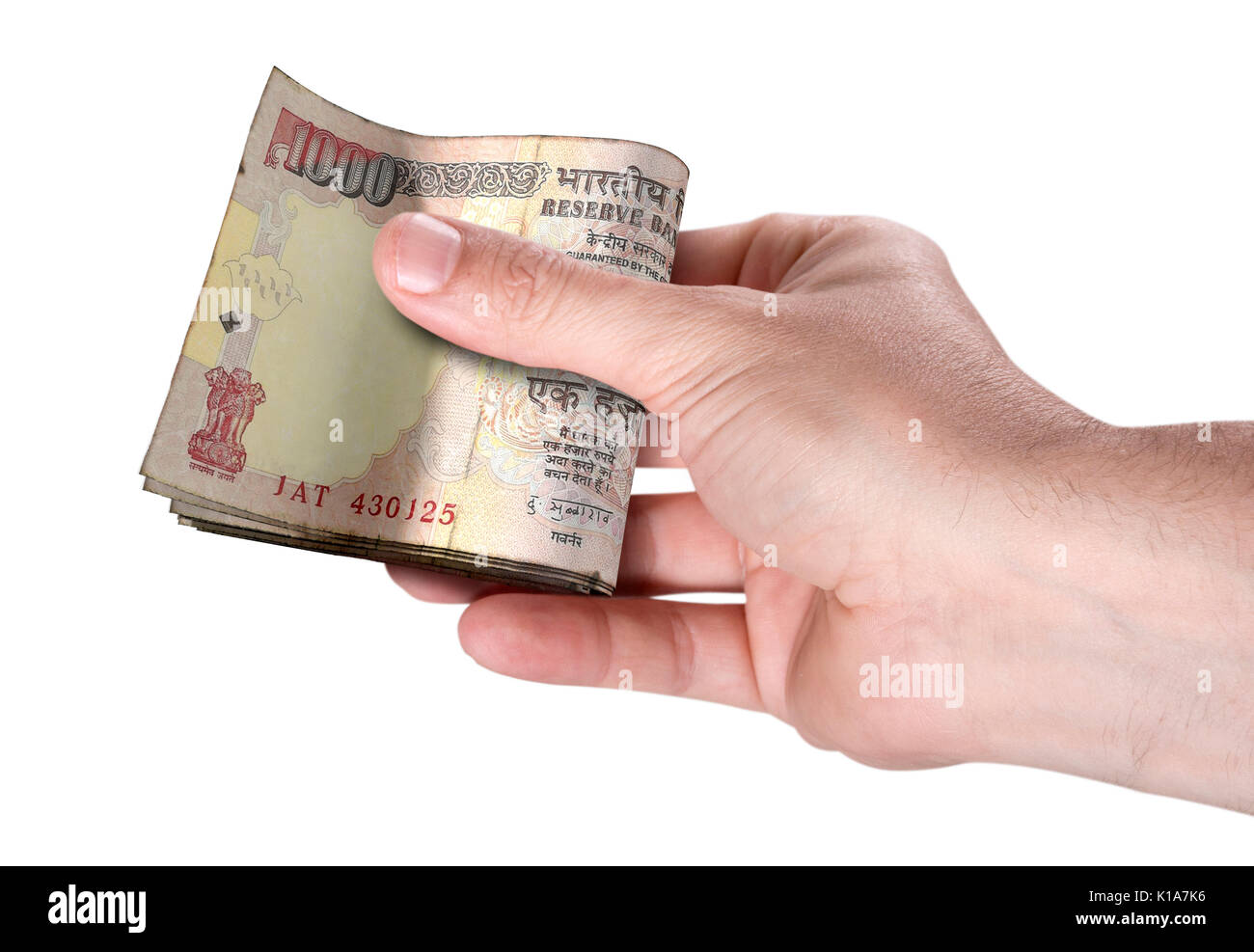 A male hand handing over a wad of folded indian rupee bank notes on an ...