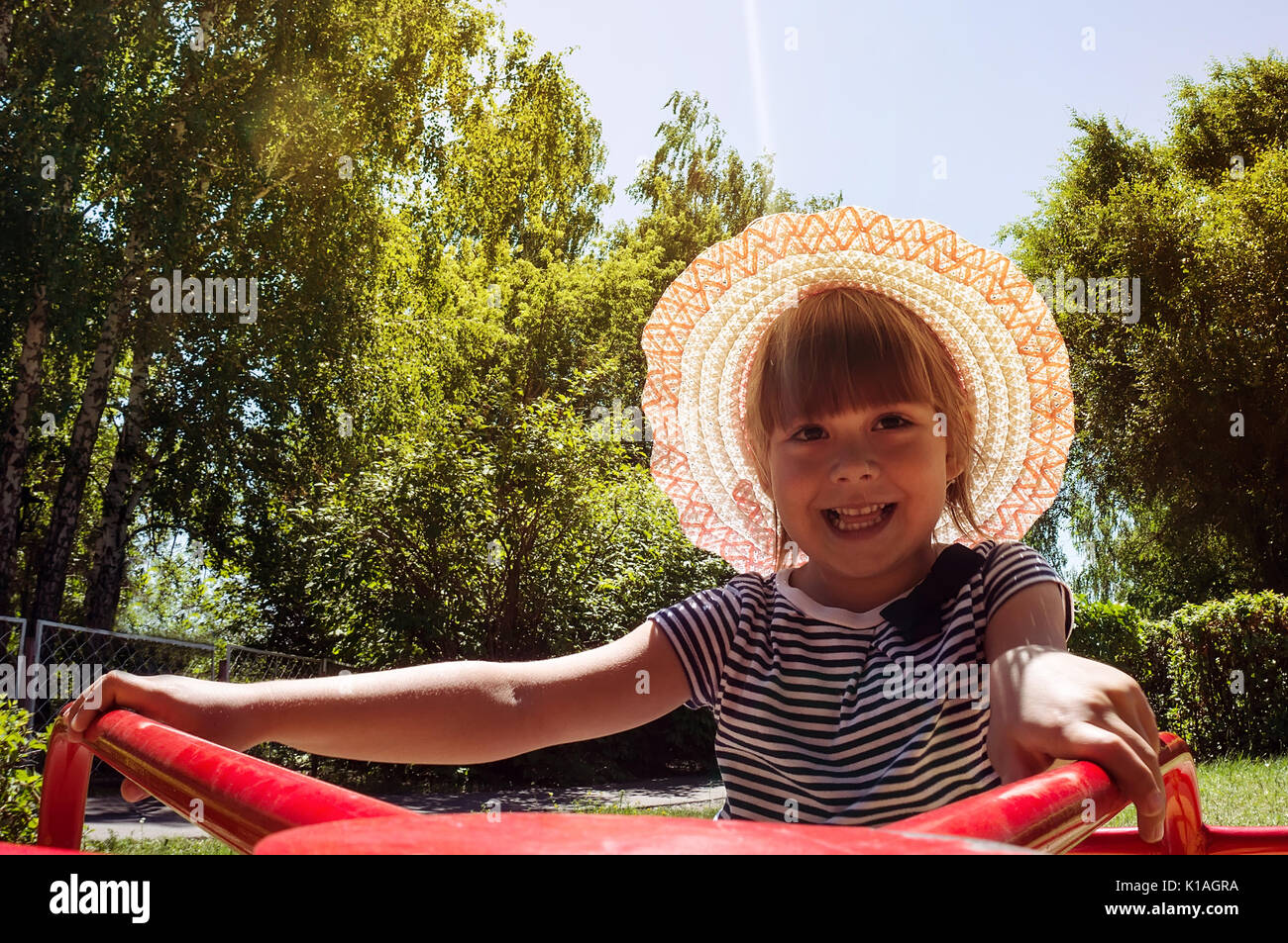 A little girl riding a carousel in the Playground. children's ...