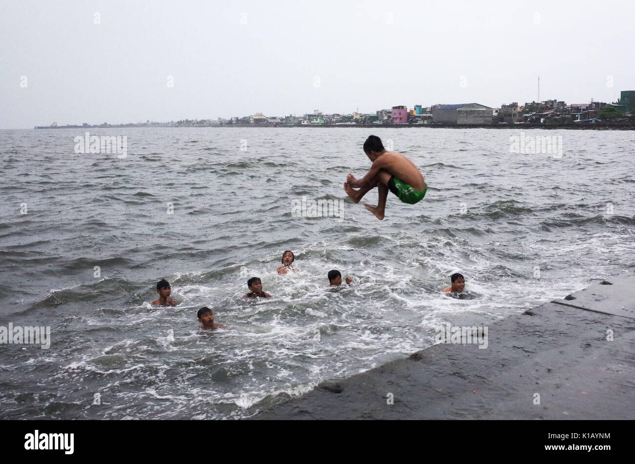 Philippines. 25th Aug, 2017. A boy jumps into the Manila Bay as his ...