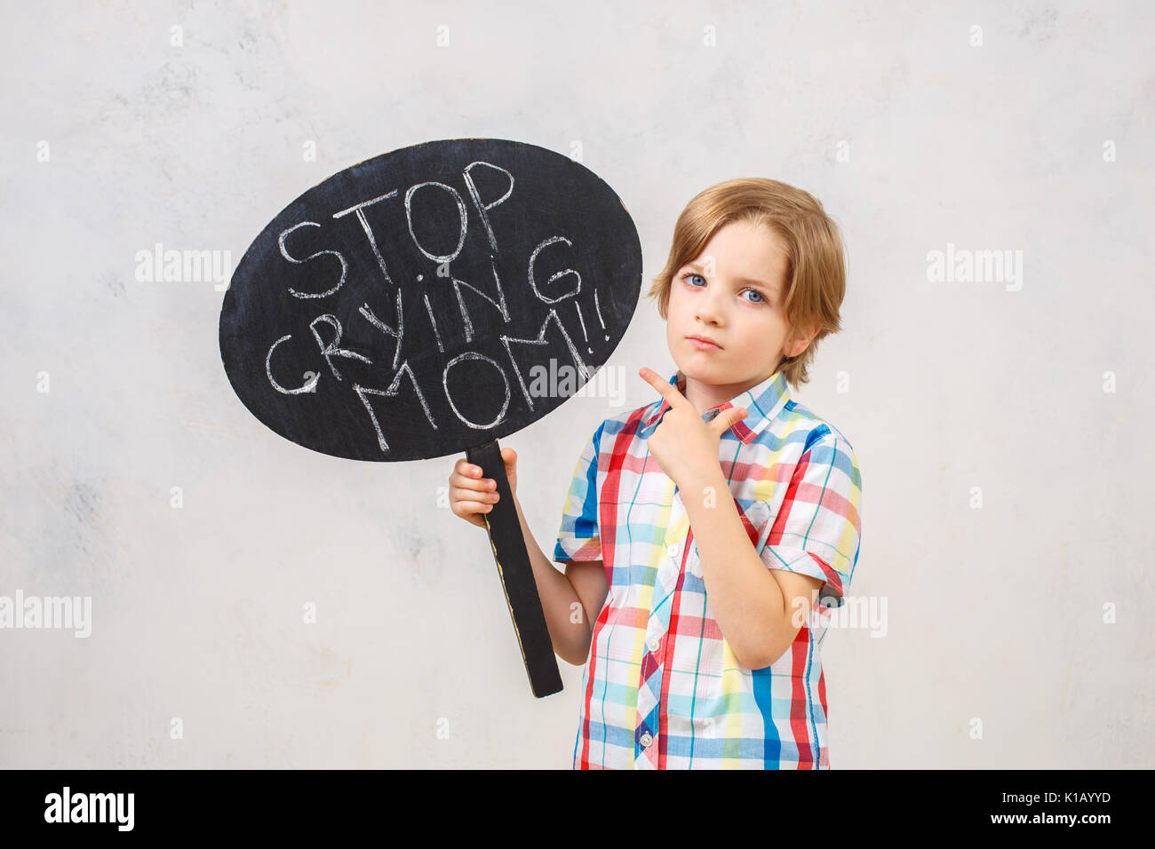 Little blonde kid isolated on white holding stop crying mom banner ...