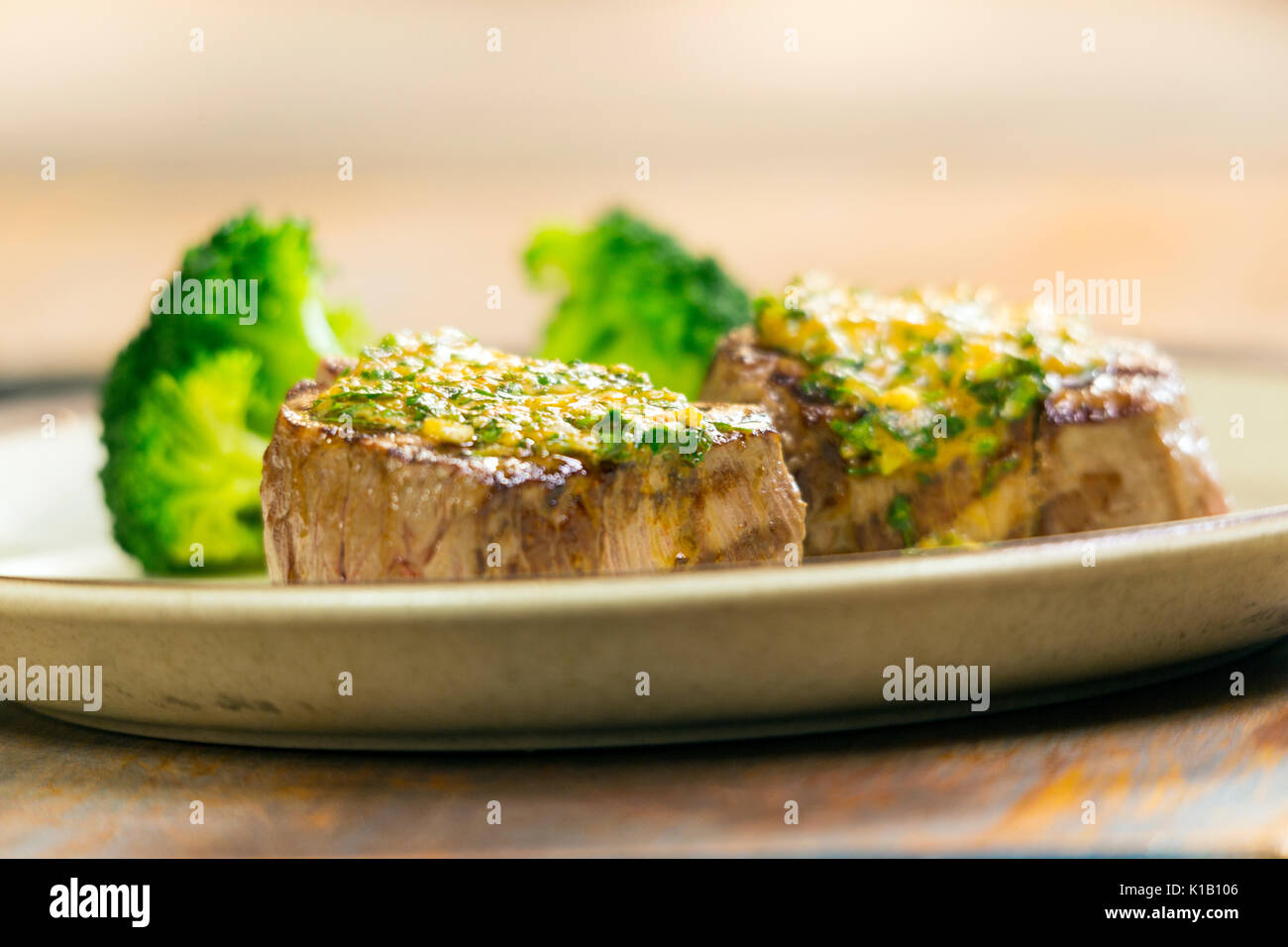 Delicious grilled beef plate served with melted butter and brocllies in ...