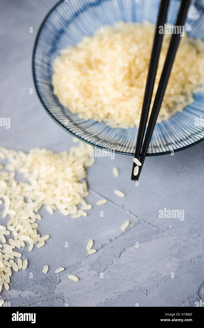 Porcelain plate and rice on grey concrete table with copyspace Stock ...
