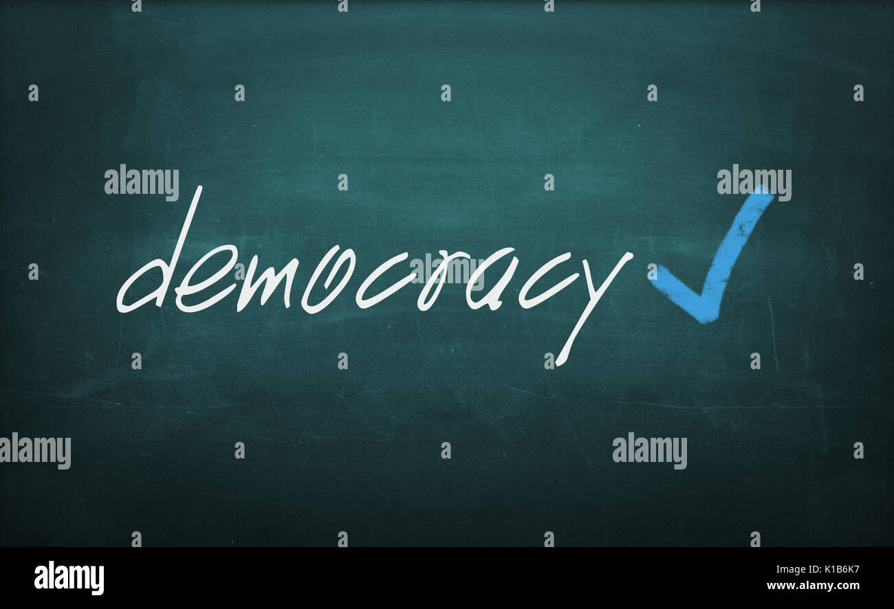 Conceptual text "Democracy" written with chalk on a dirty blackboard ...