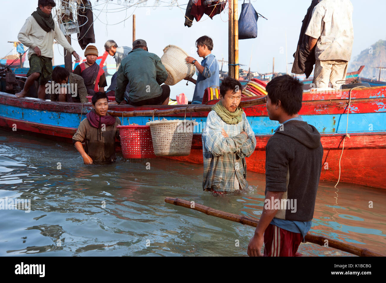 Burmese fishermen bring ashore baskets of fish onto Ngapali beach ...