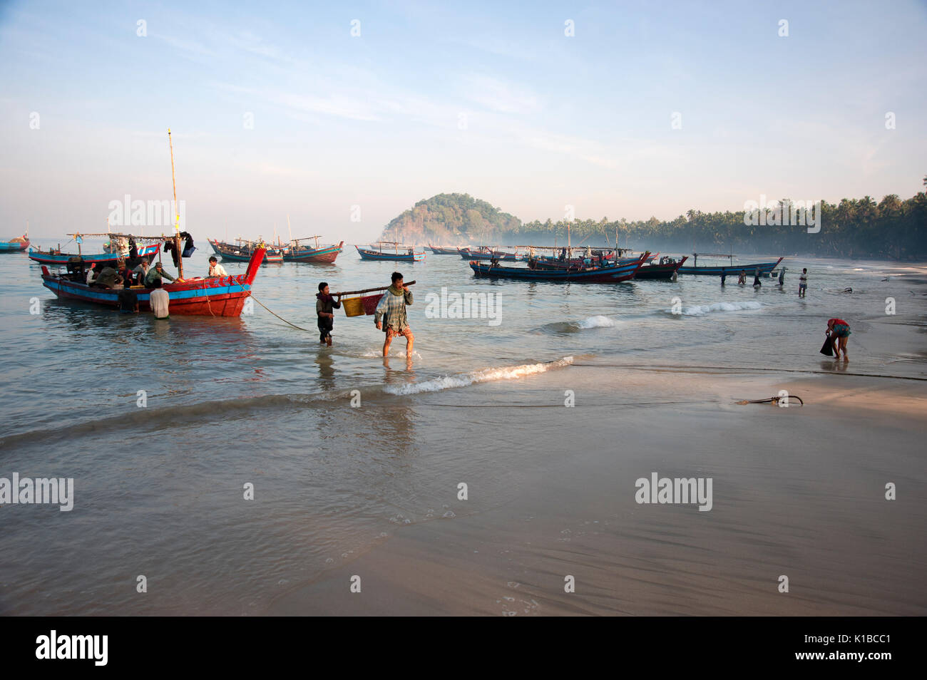 Burmese fishermen bring ashore baskets of fish onto Ngapali beach ...