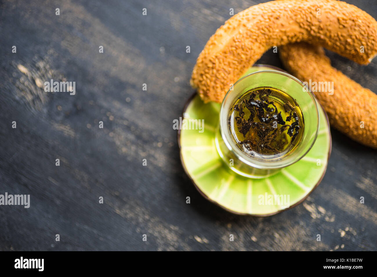 Glass of tea and traditional turkish snack - simit, on dark wooden ...