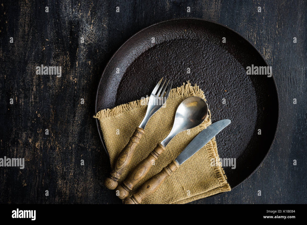 Rustic table setting ith vintage metal plate and cutlery on dark wooden ...