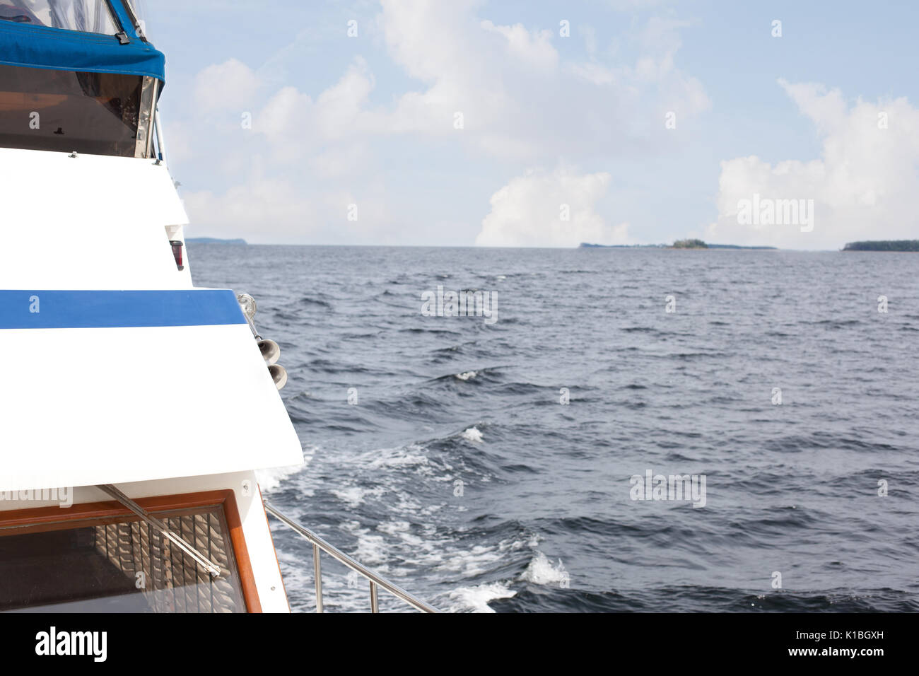 A white and blue motor sailing vessel with silver horns rides along in ...