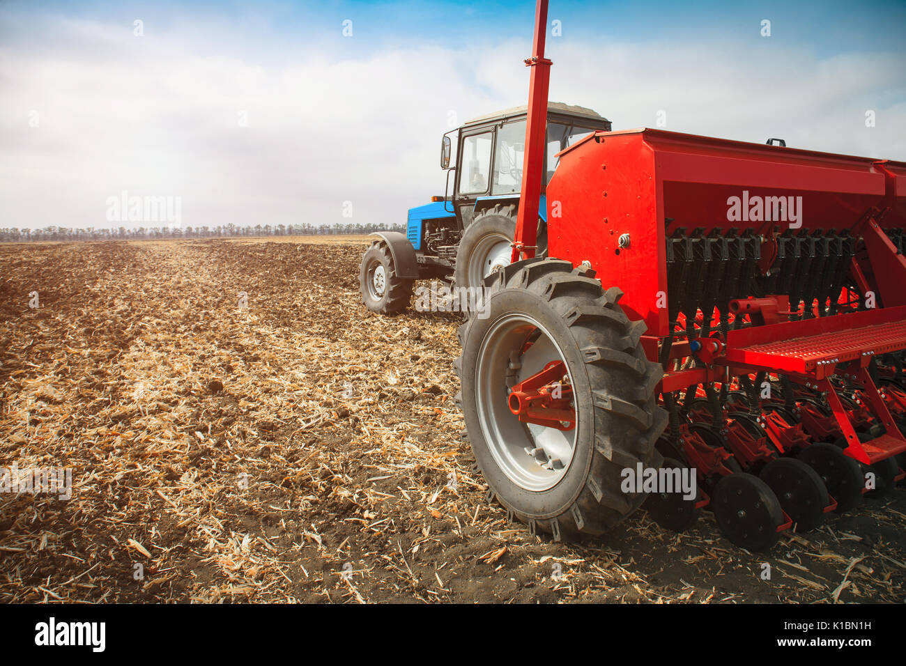 Modern tractor in the field with sowing complex. The concept of work in ...