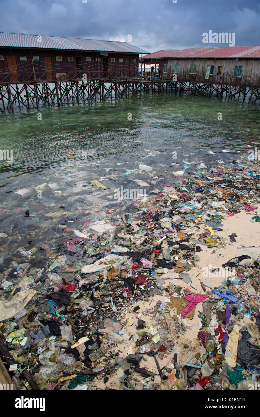 Plastic trash and other garbage covers a beach in front of budget dive ...