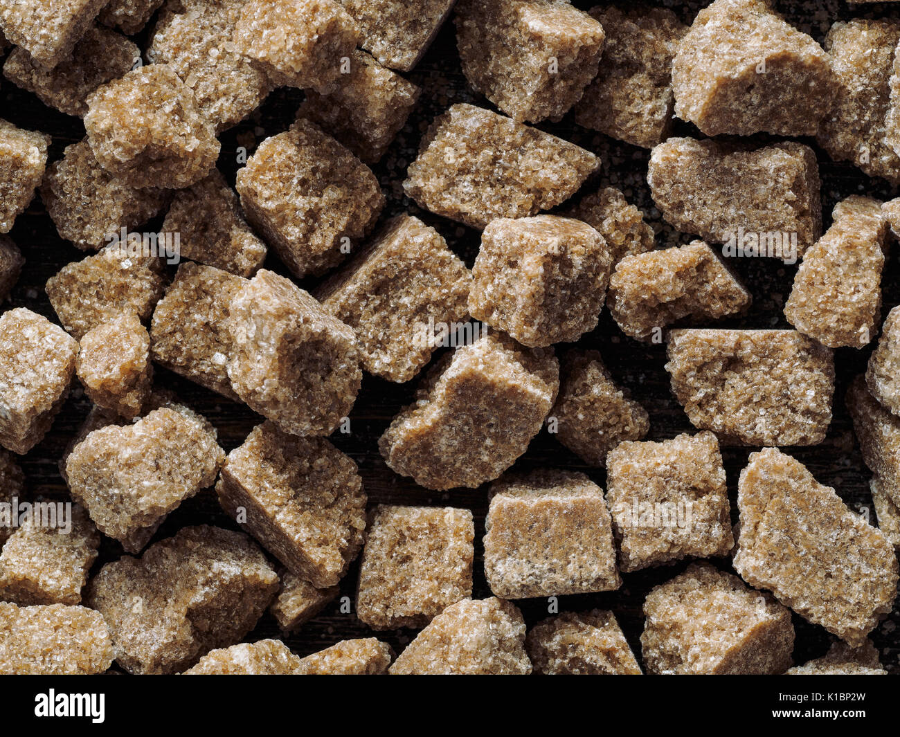 natural raw brown cane sugar cubes close up as background. Top view of ...
