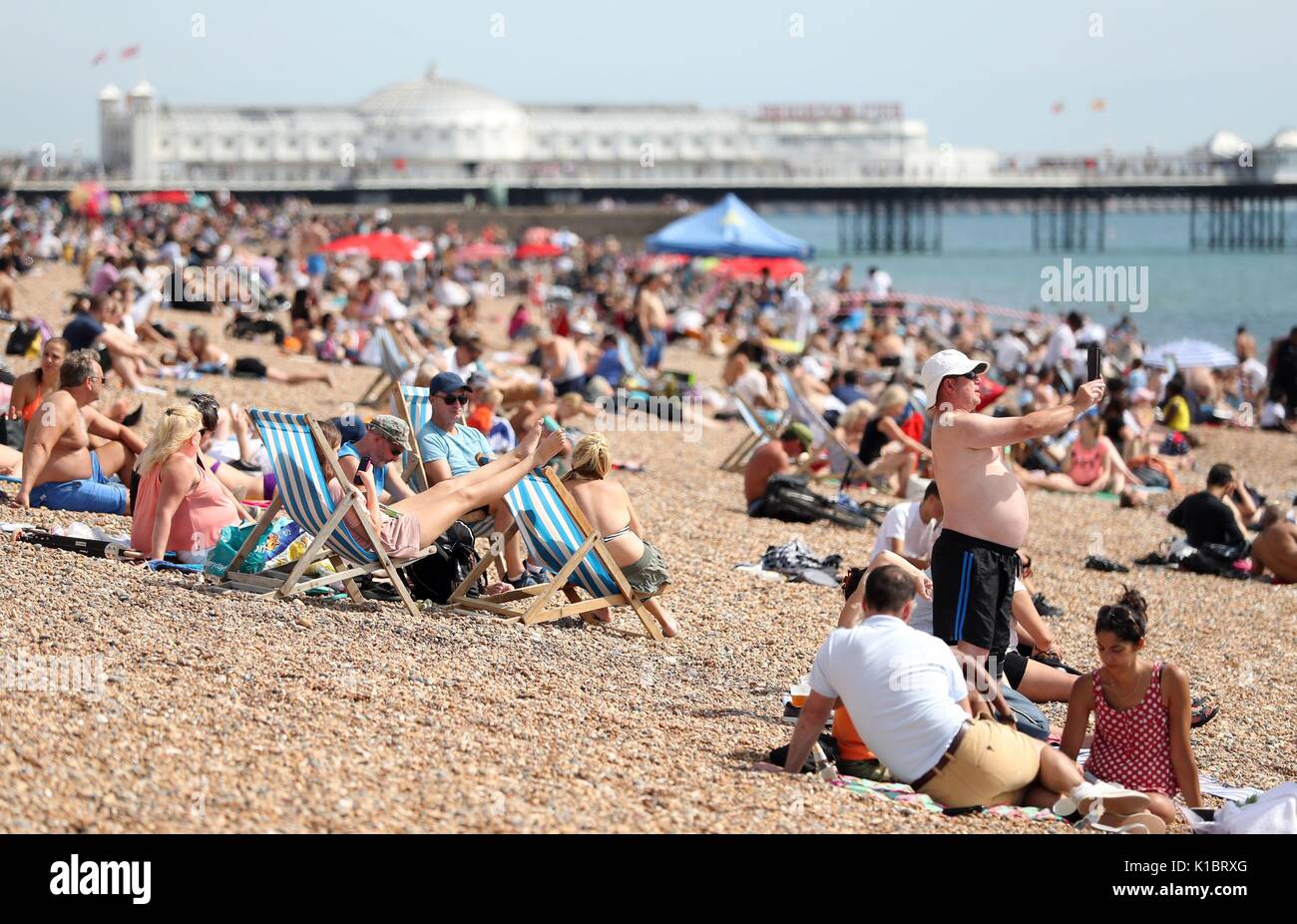 People sunbathe on brighton beach in sussex hi-res stock photography ...