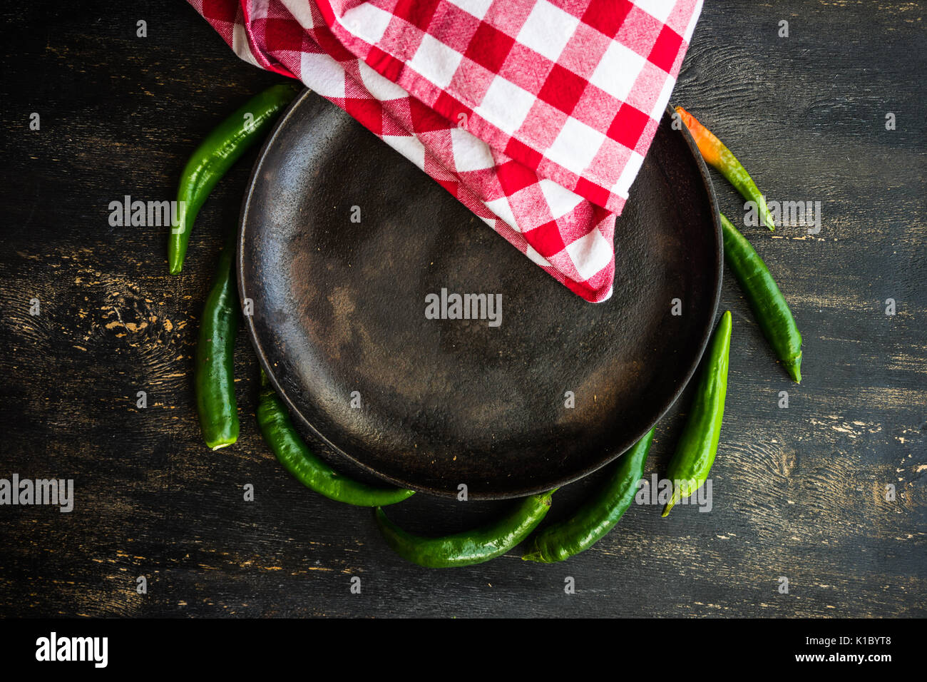 Organic chilli peppers on a pan on dark wooden background with ...