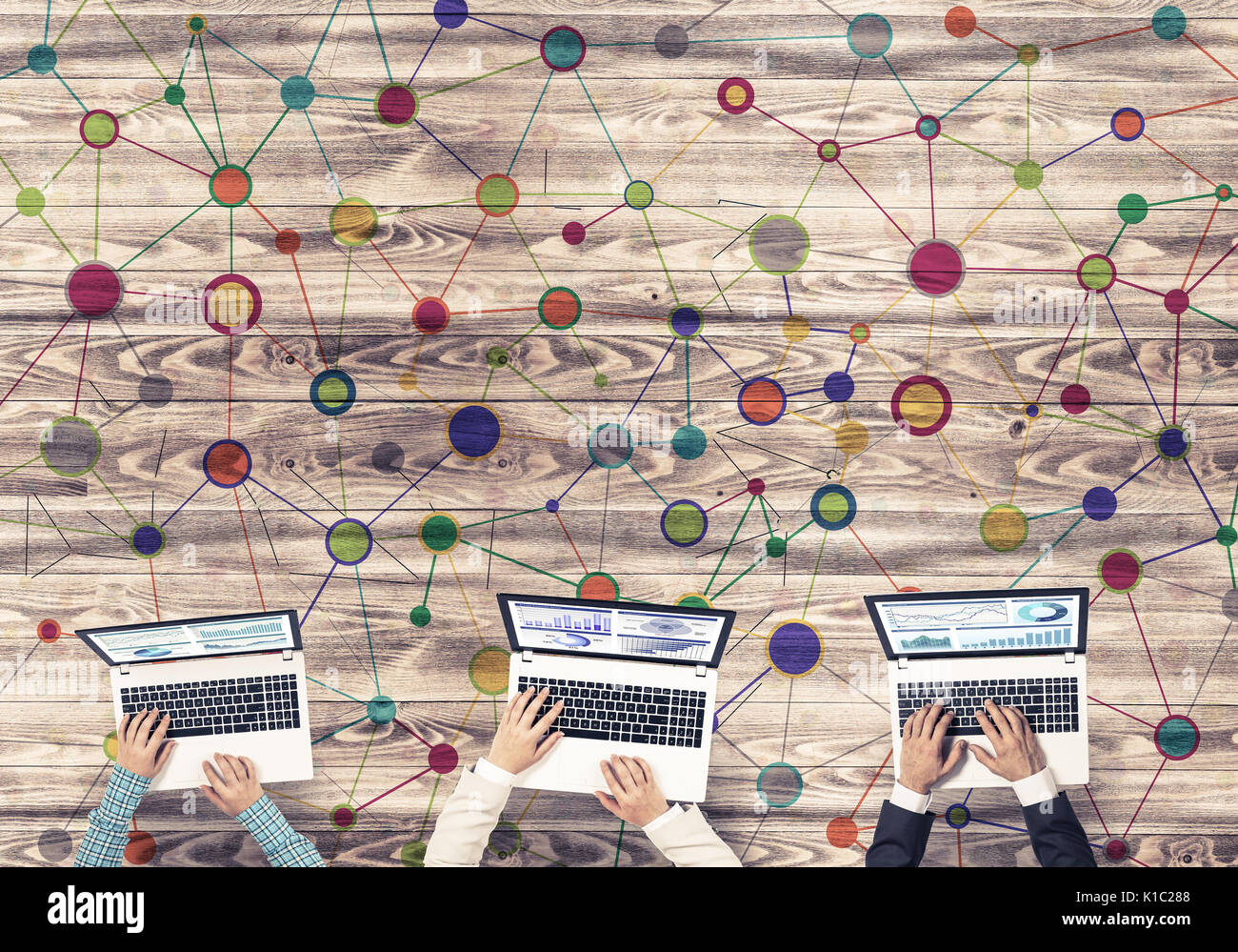 Group of three people with devices in hands working together as symbol ...