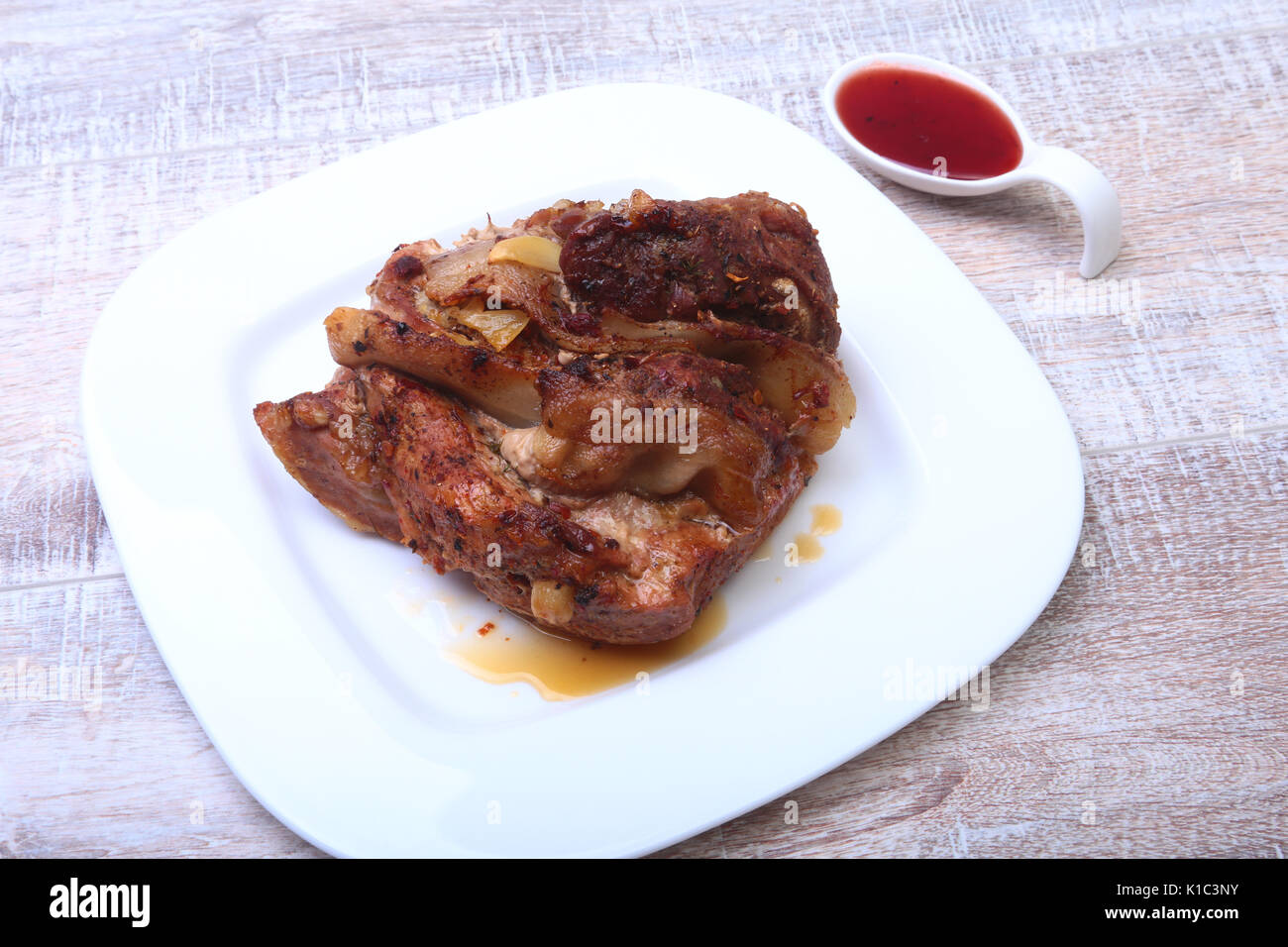 Steak of grilled meat with red sauce on white plate Stock Photo - Alamy