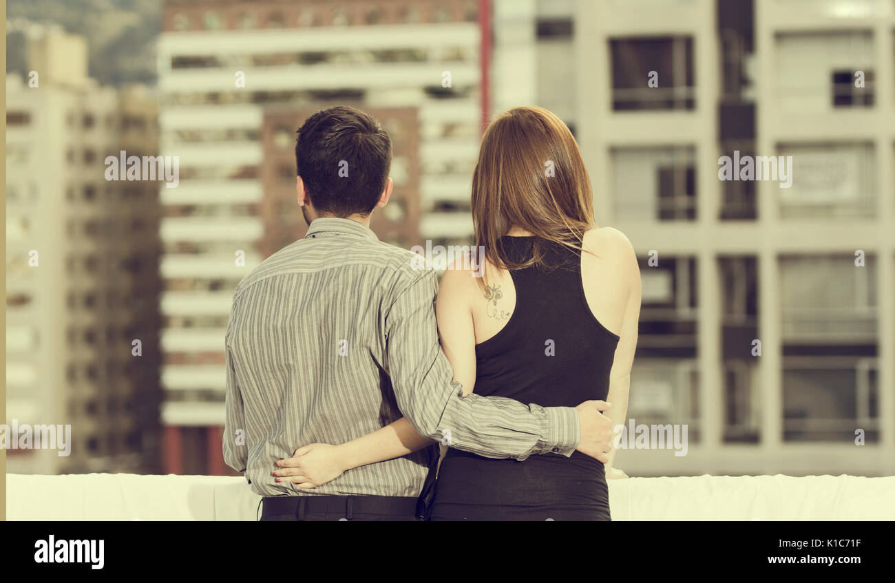 Beautiful young couple hugging in a blurred background, back view ...