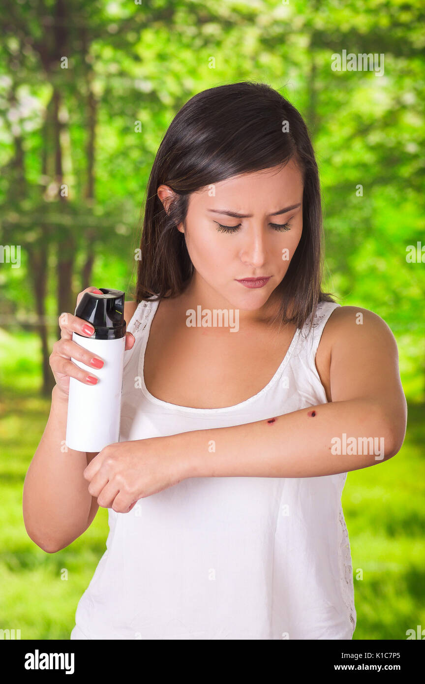 Close up of young woman suffering from itch after mosquito bites, using ...