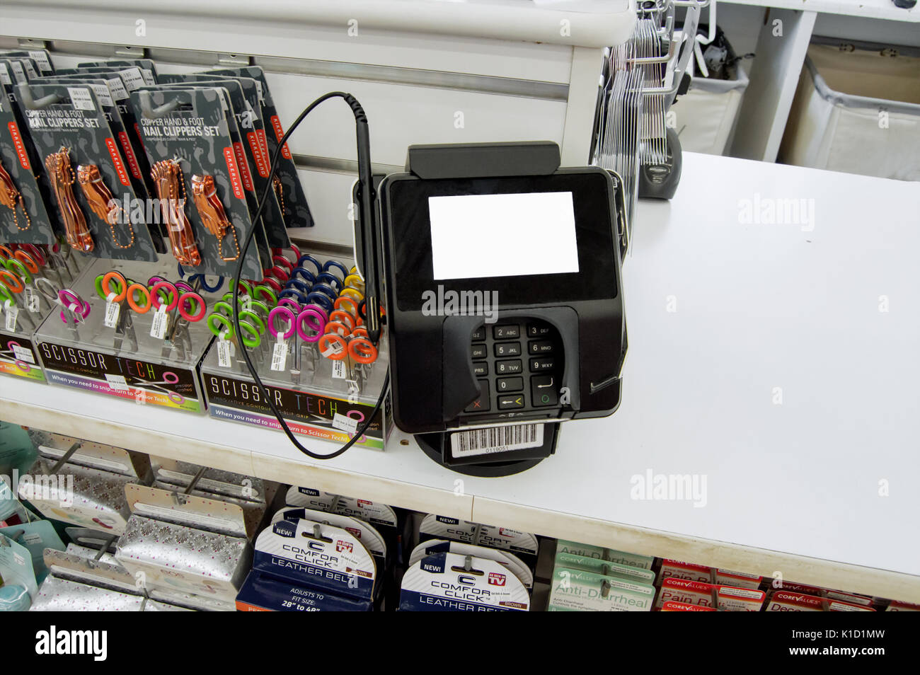 A checkout credit card reader with accessories beside it at a ...