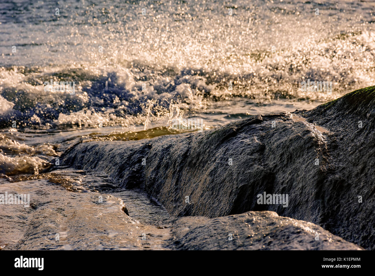 Sea water breaking and the stones with drops of water in the air Stock ...