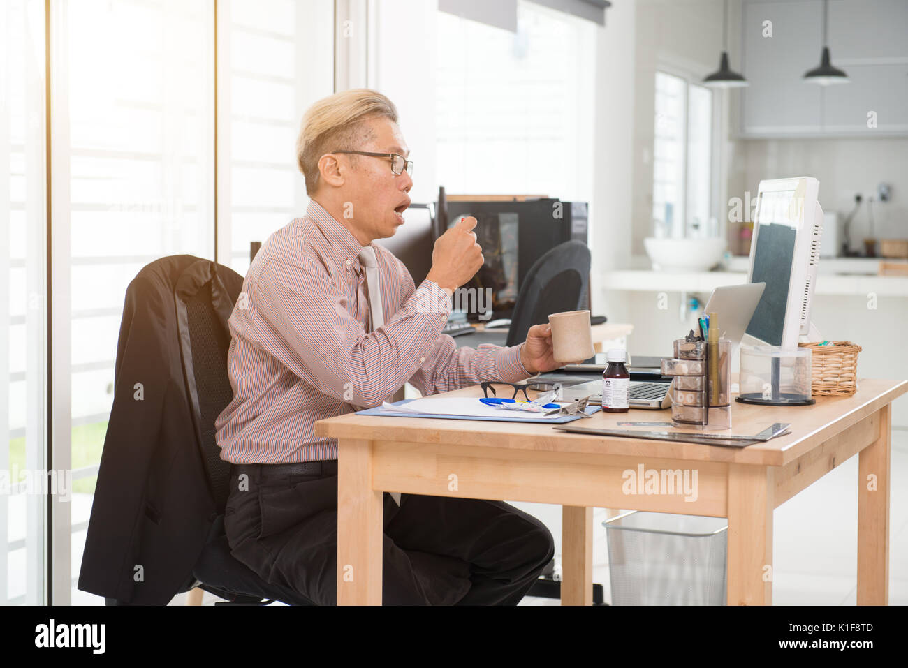 asian senior business man taking medicine at work Stock Photo - Alamy
