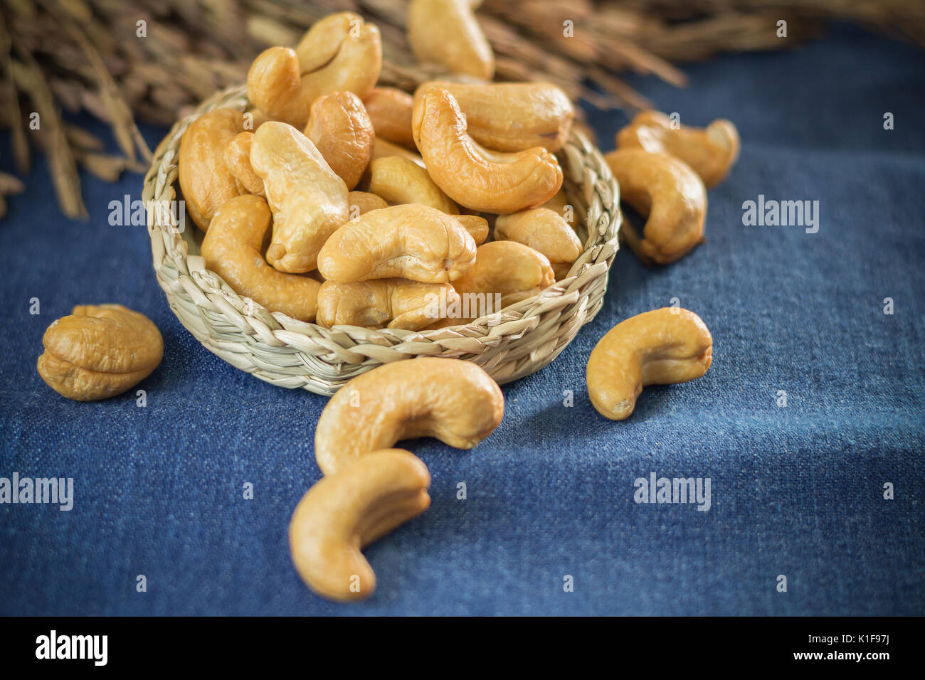 Roasted cashew nuts on blue canvas background (soft focus Stock Photo ...