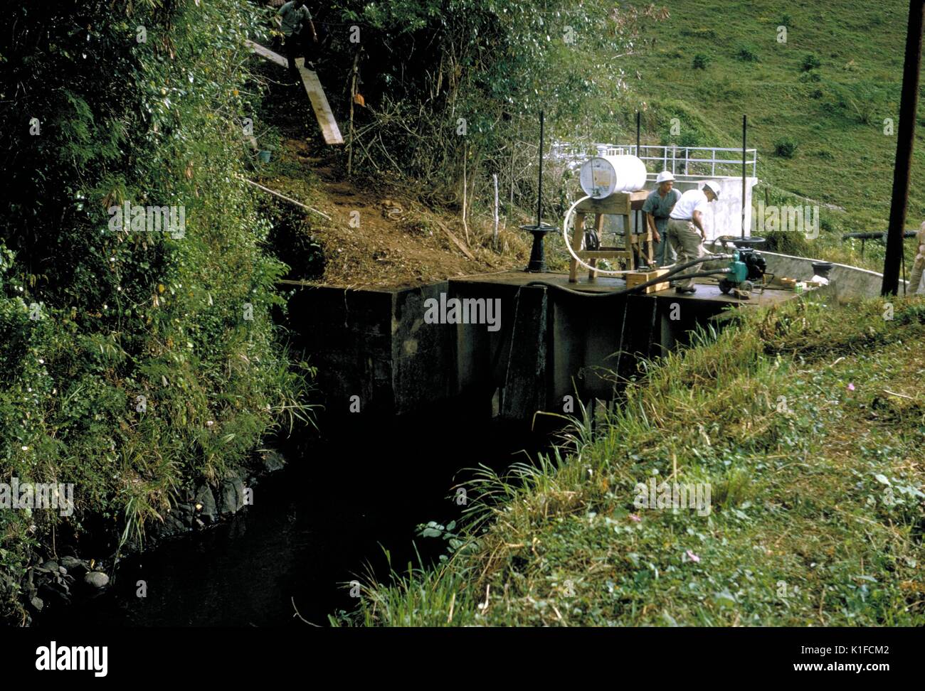 Puerto Rican sanitation workers applying acrolein to stream to control ...