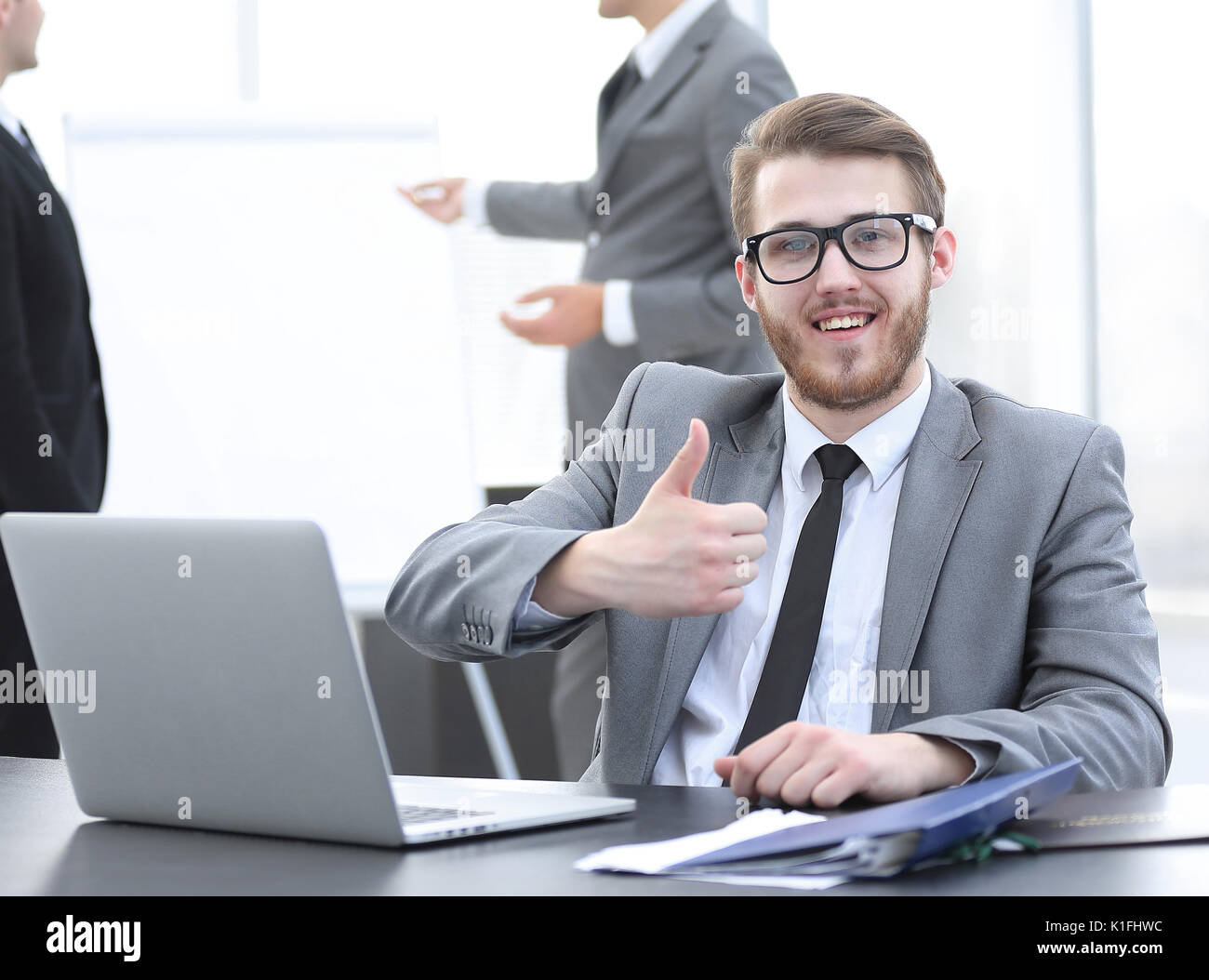 Manager sitting at his Desk and showing thumbs up Stock Photo - Alamy
