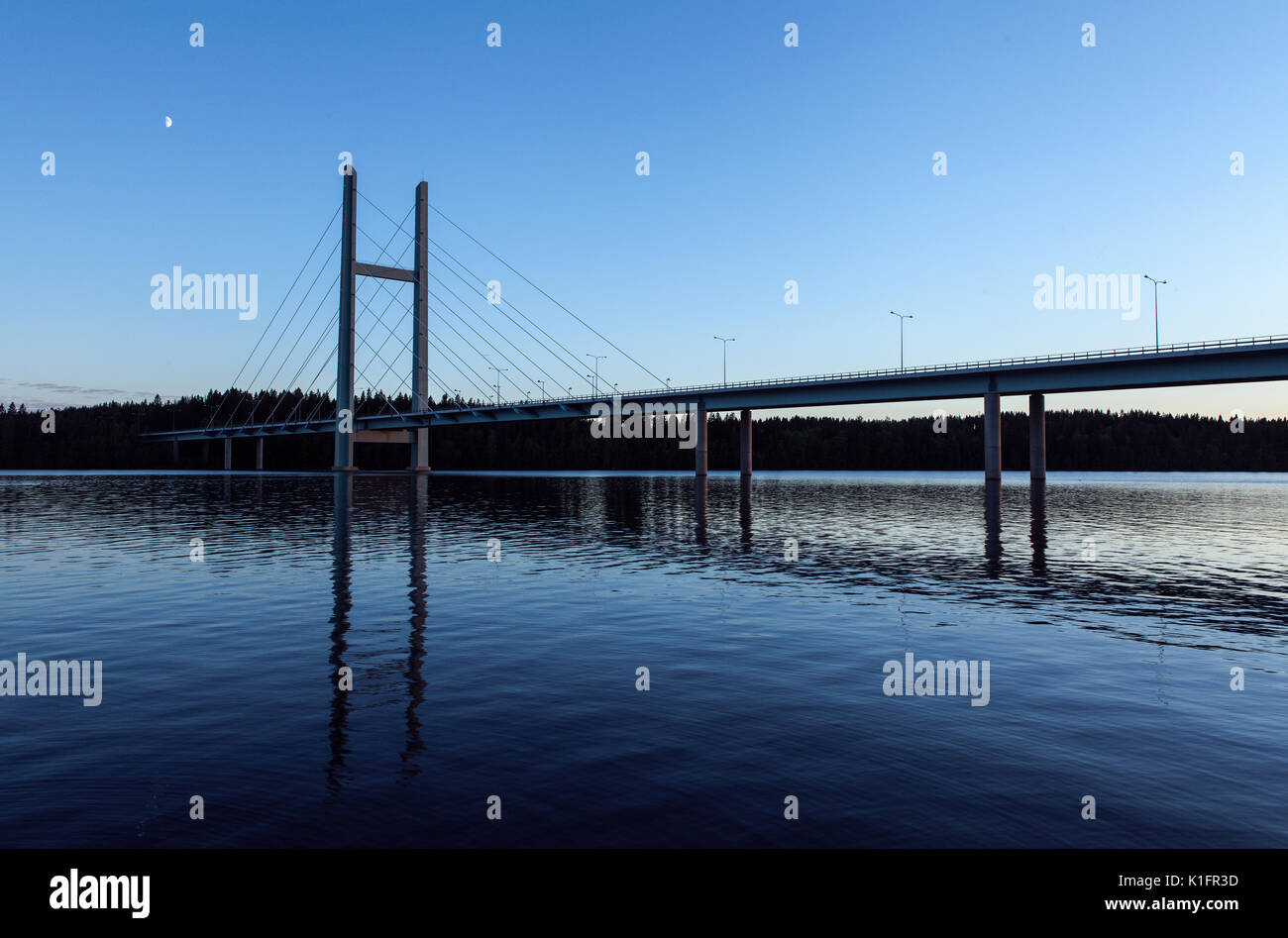 A cable-stayed harp form bridge in evening lit. Water and moon Stock ...