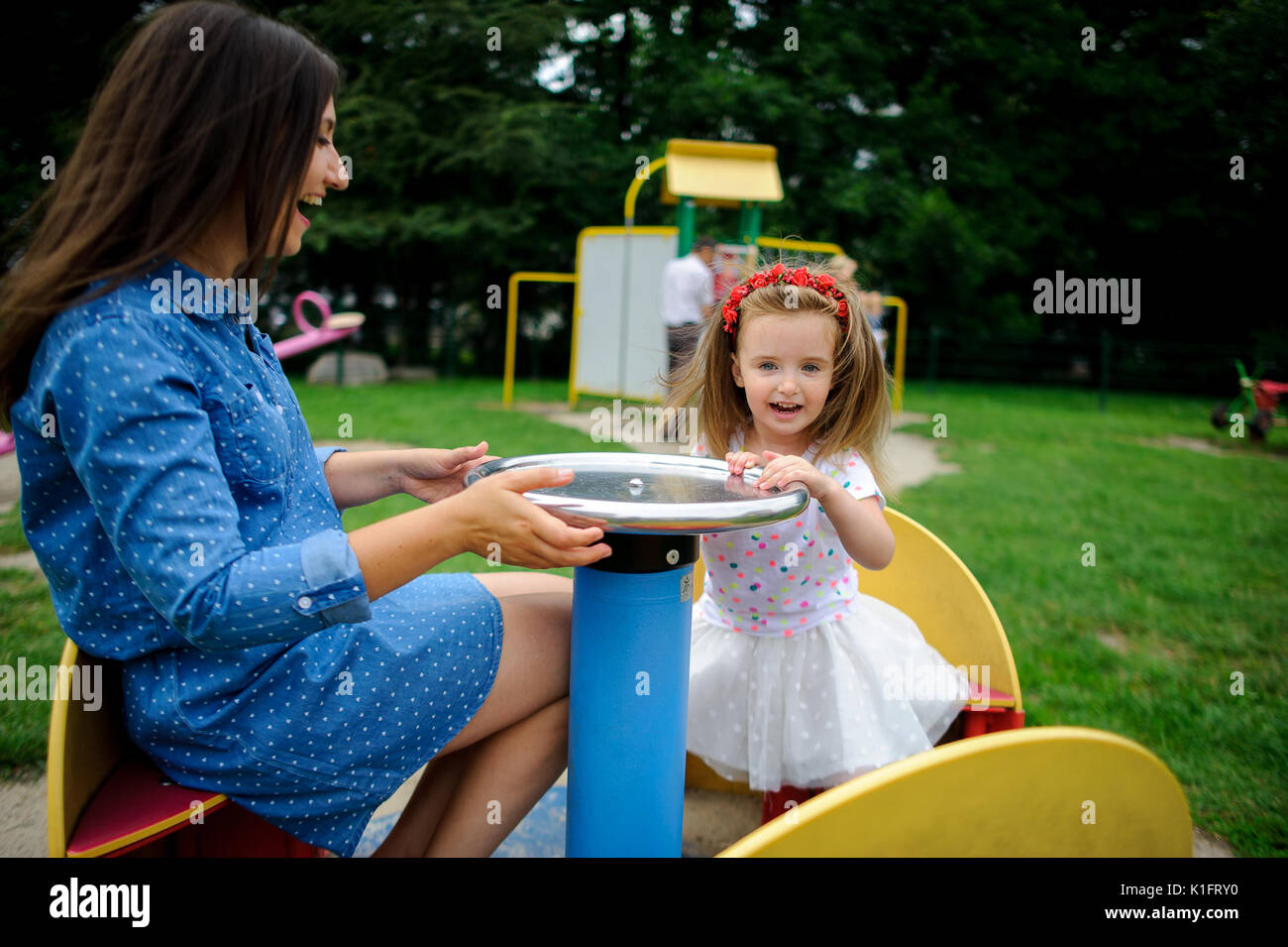 Young mother plays in the playground with the little daughter. Woman ...