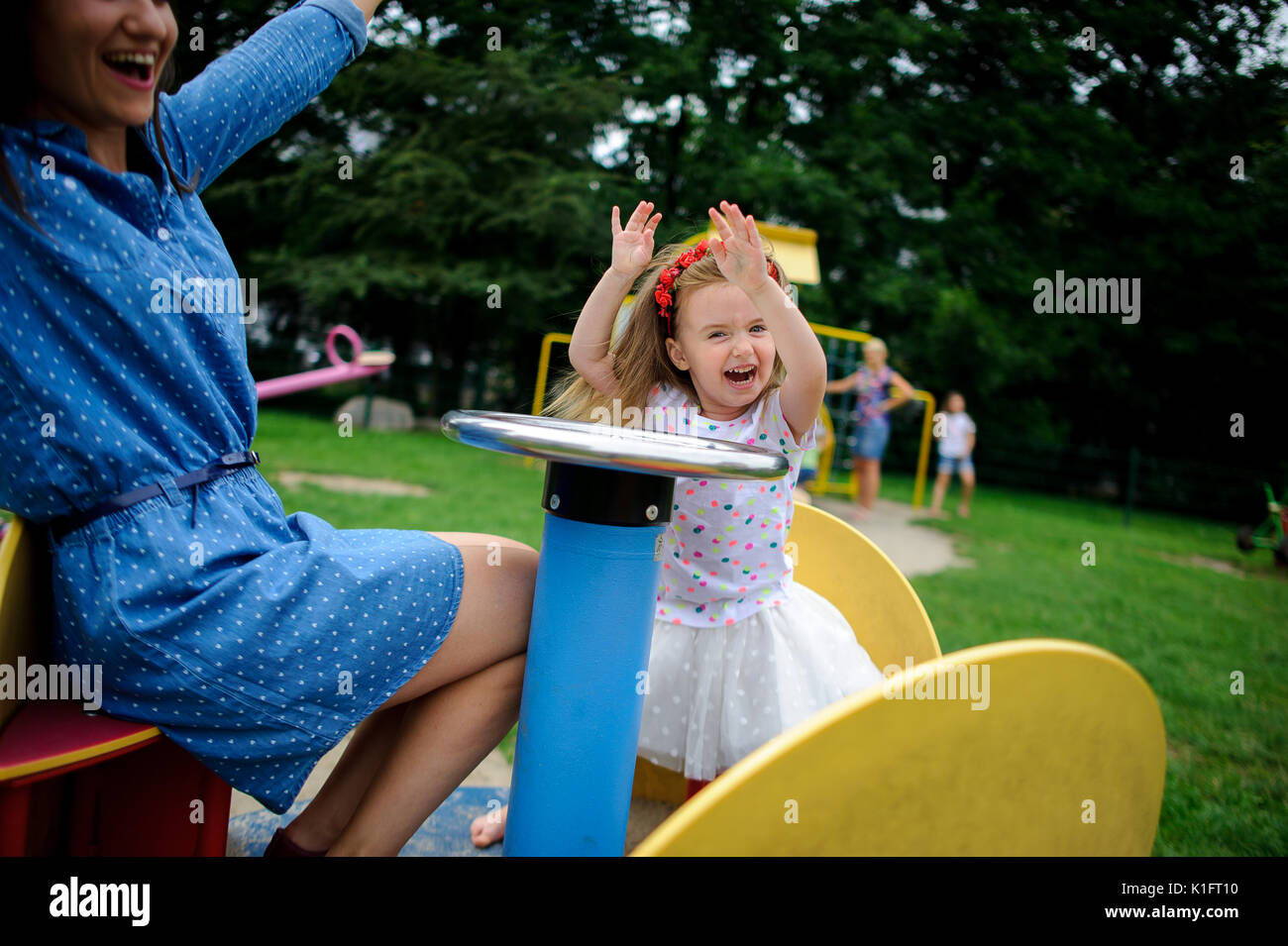 Young mother plays in the playground with the little daughter. Woman ...