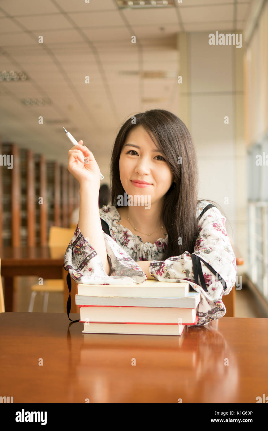 asian girl in library reading book Stock Photo - Alamy