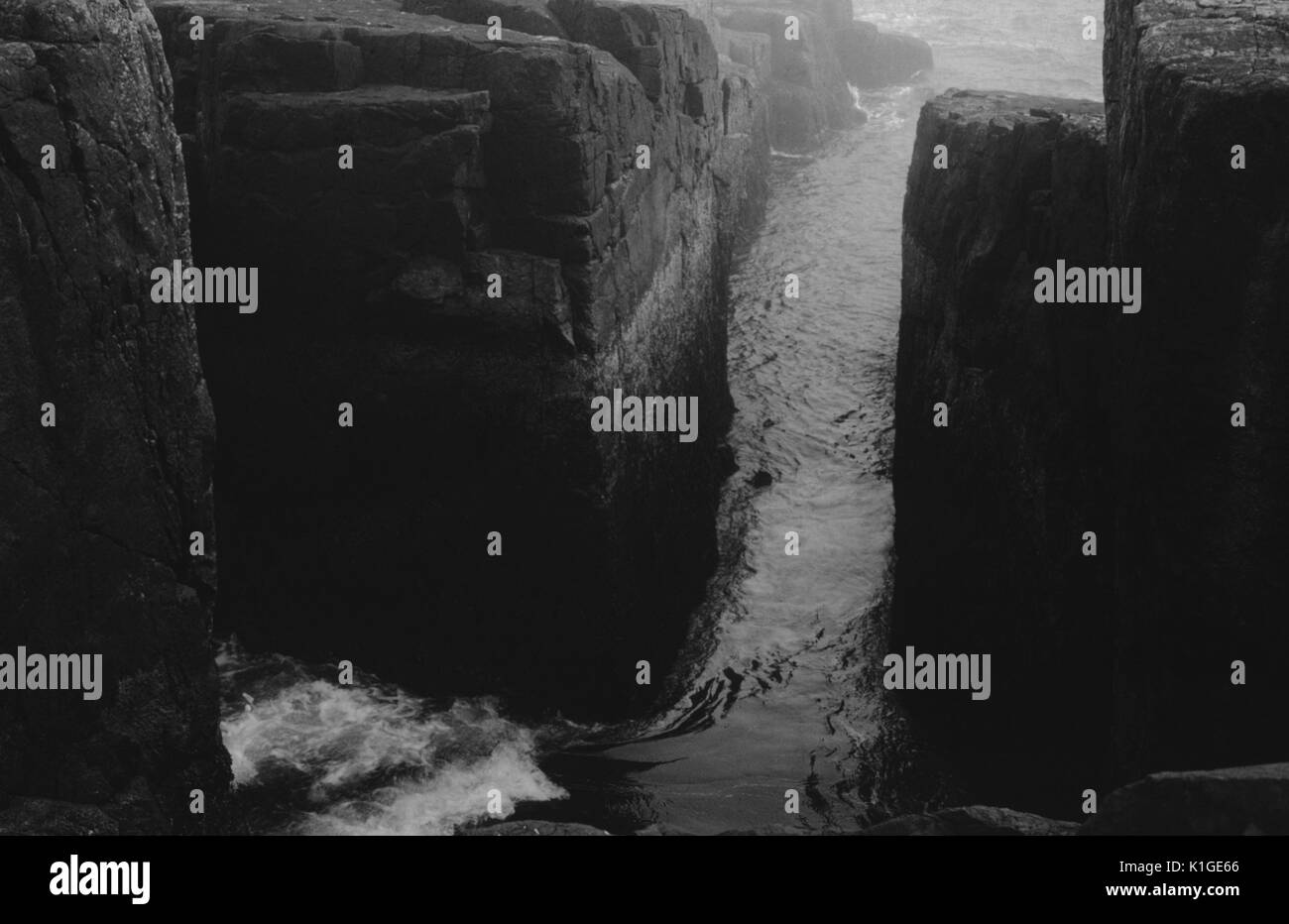 Large black rock cliffs, ocean breaking at the bottom, Scotland, 1966 ...