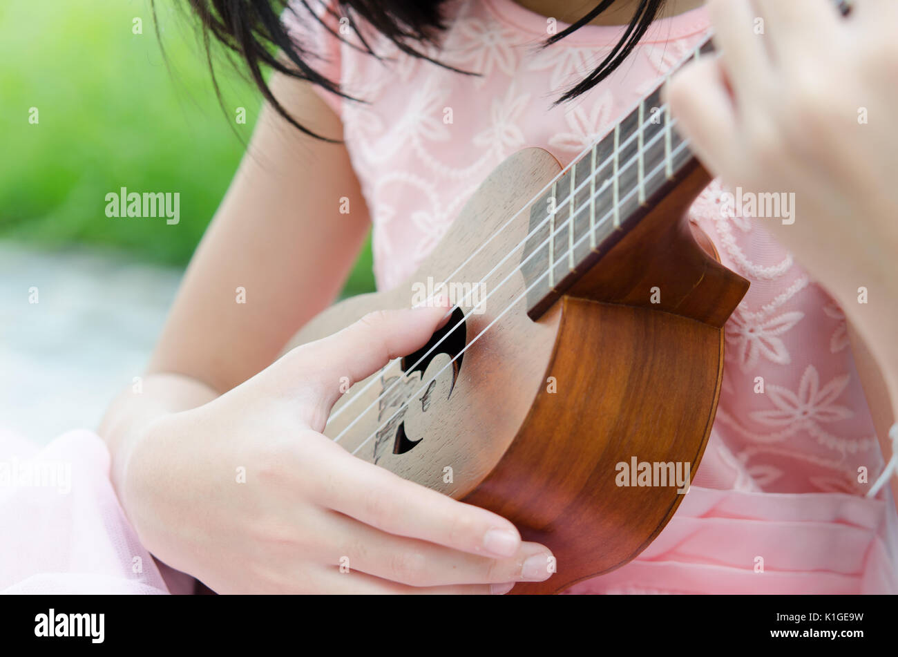 Young girl playing on ukulele Stock Photo - Alamy