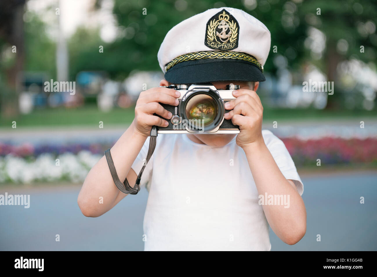 kid wearing captain cap takes a picture using vintage film camera Stock ...