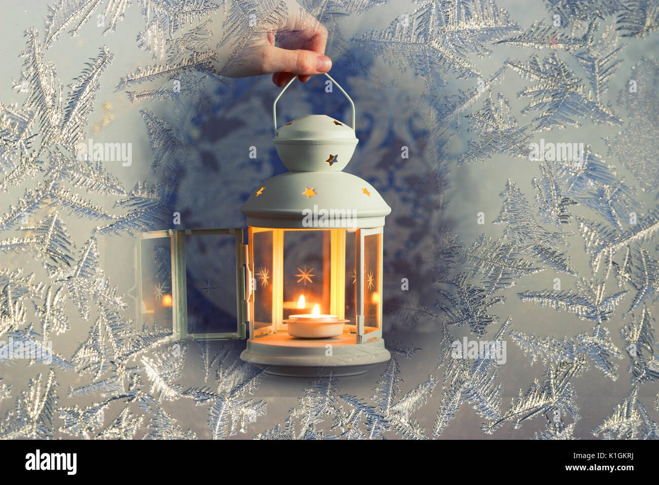 view of a lantern through frozen window. winter house Stock Photo - Alamy