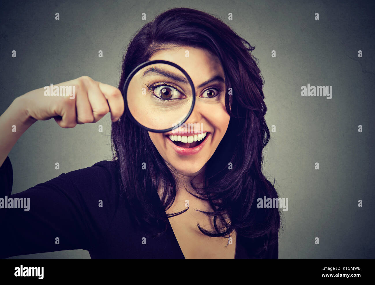 Curious surprised woman looking through a magnifying glass Stock Photo ...