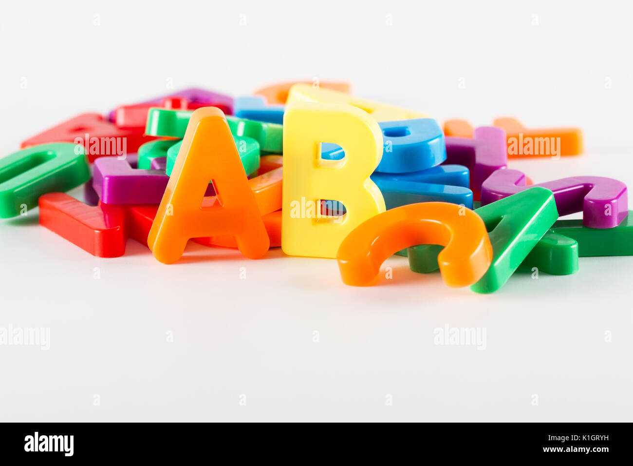 Colorful plastic alphabet letters on white background Stock Photo - Alamy