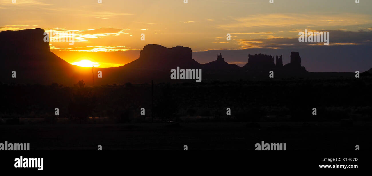 The sun is raising behind the rock formations of Monument Valley, USA ...