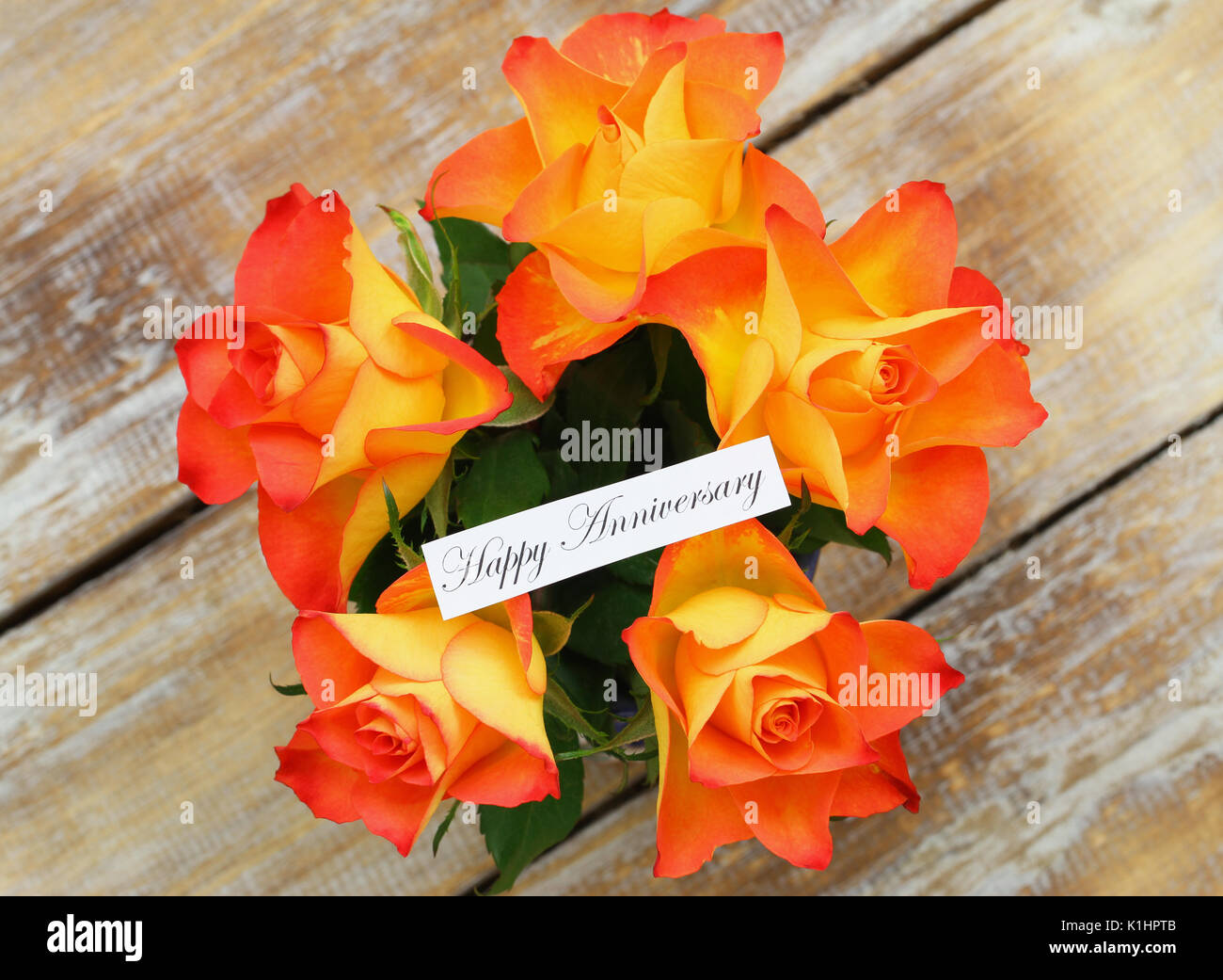 Happy Anniversary card with orange roses bouquet on rustic wooden ...