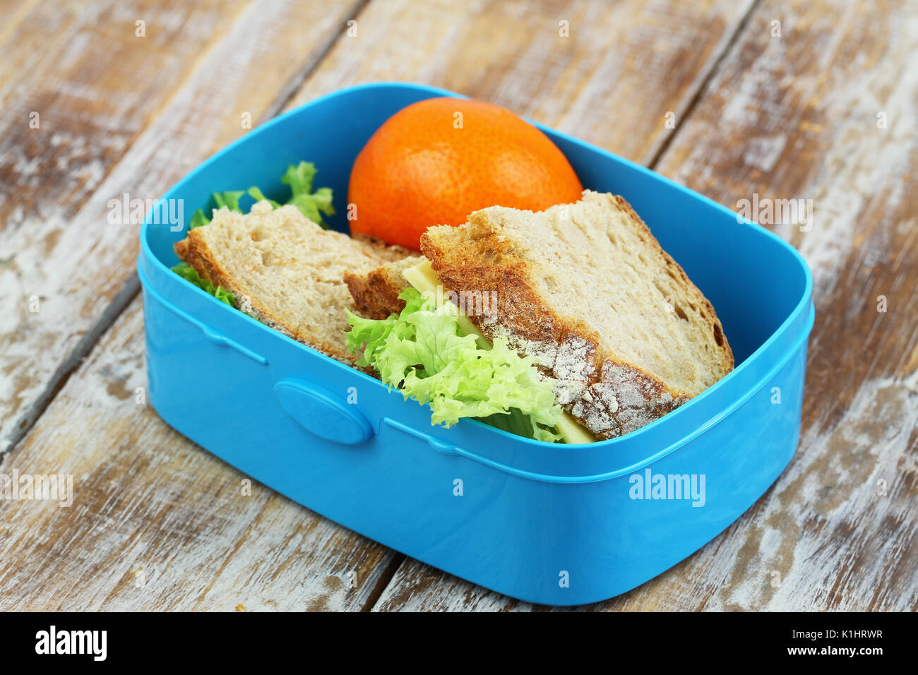 Rustic bread sandwiches with cheese and lettuce in lunch box and ...
