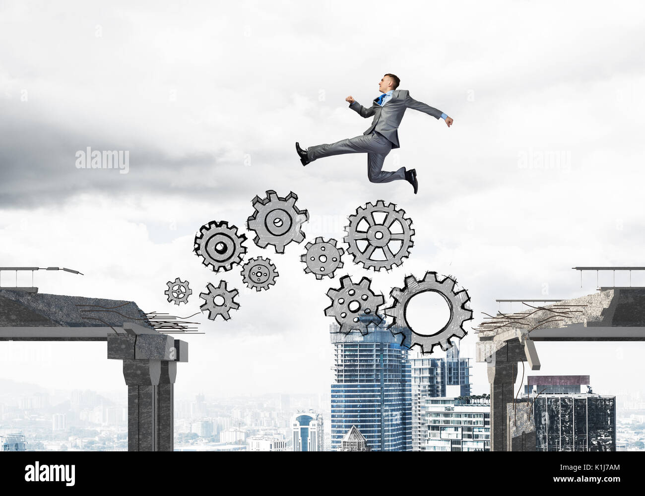 Businessman jumping over gap with gear mechanism in concrete bridge as ...